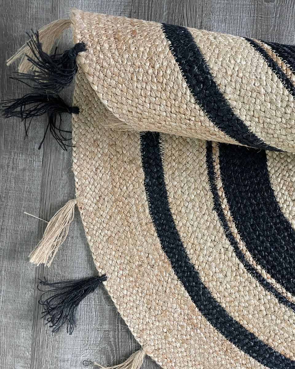 Handwoven round jute rug with black accents and tassels. Eco-friendly ...